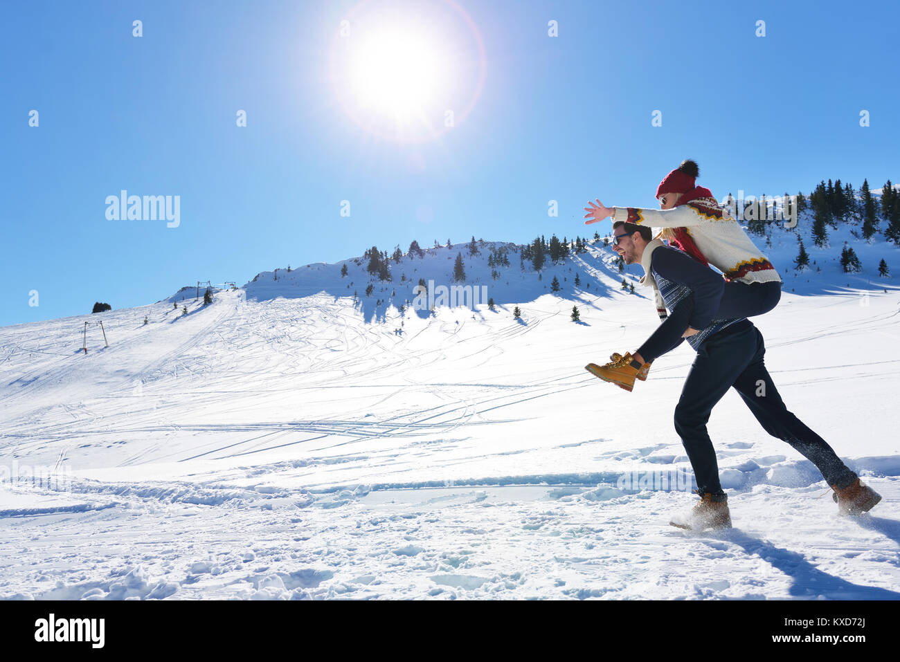 Young couple having fun on snow. Happy man at the mountain giving ...