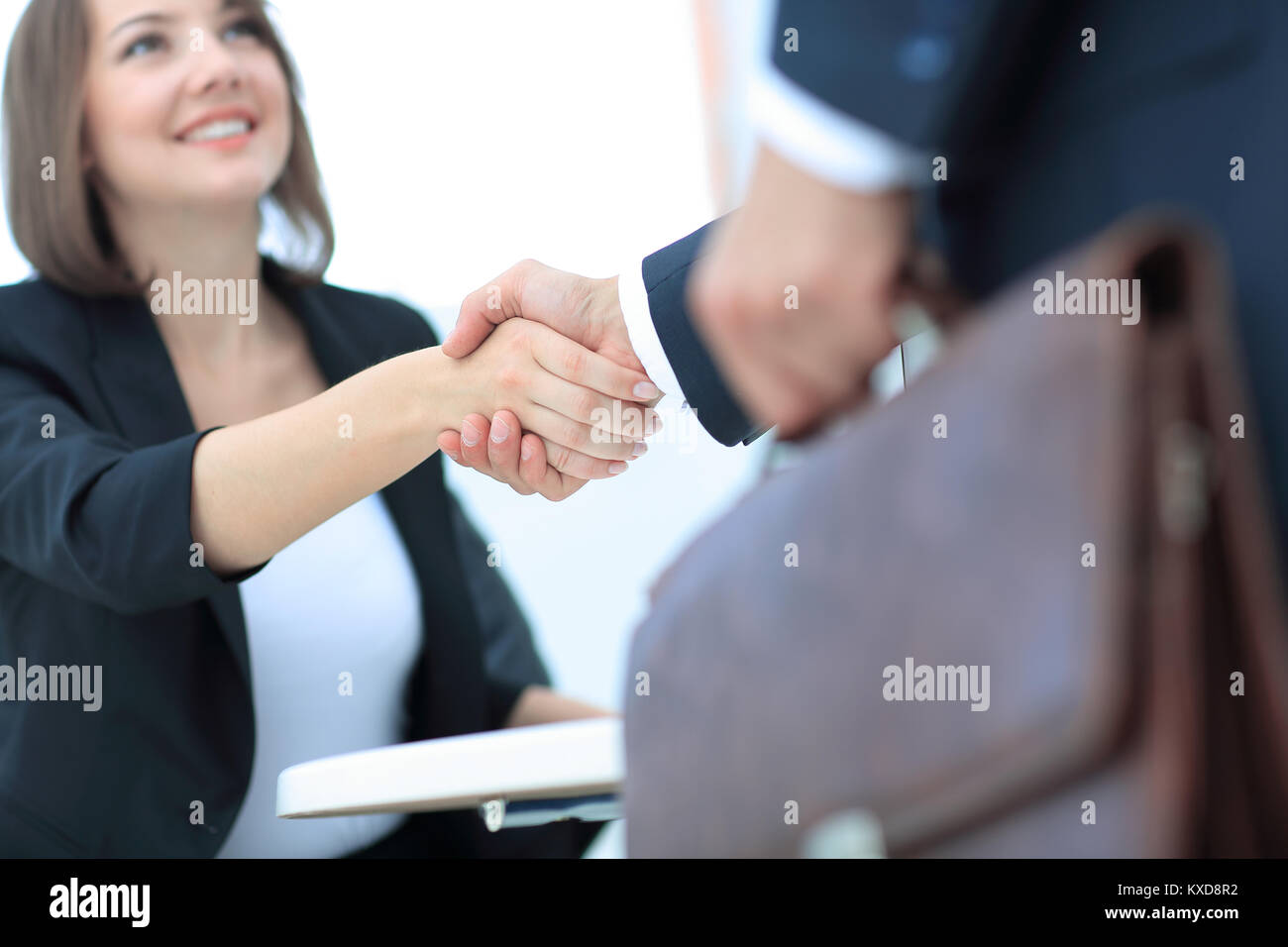 Two handsome men shaking hands with smile while sitting Stock Photo - Alamy