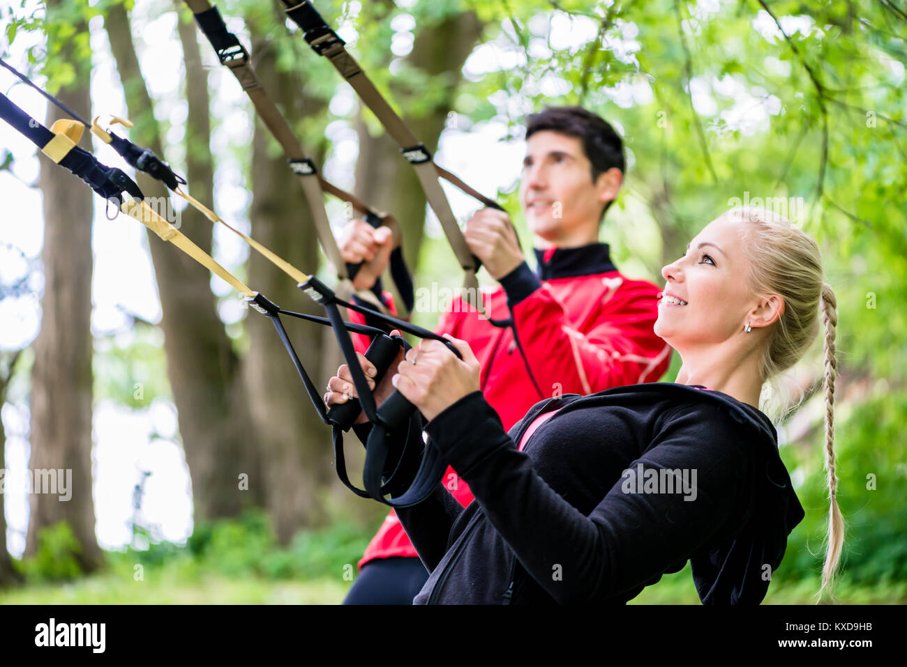 Sporty couple at sling trainer doing fitness Stock Photo - Alamy