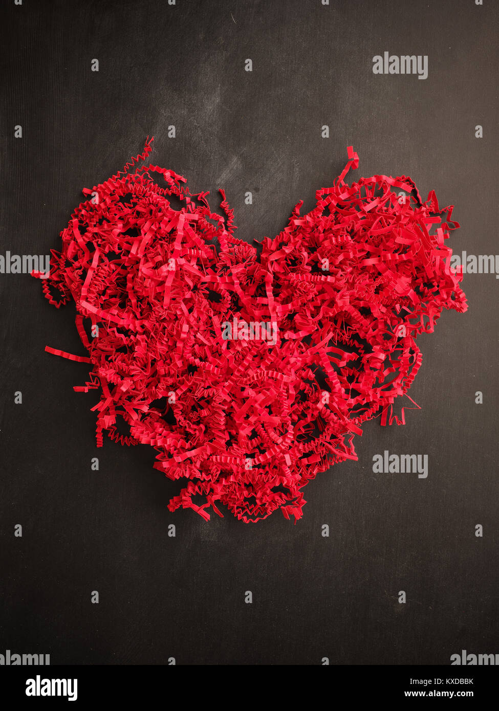 Shredded red paper shaped as a heart shape on a chalkboard, Valentines ...