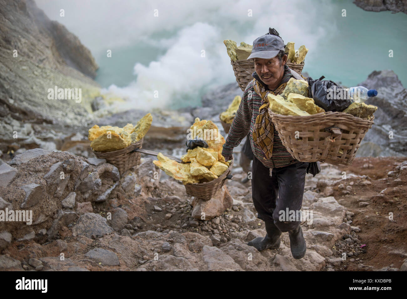 Sulfur miner carrying heavy load of Sulphur at top of Kawah Ijen ...