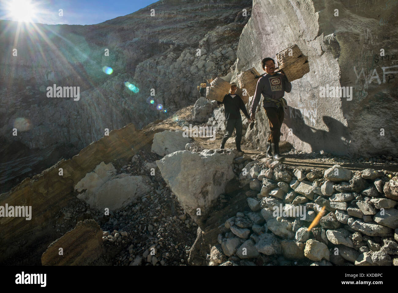 Miners with empty baskets heading down to volcano crater to collect ...