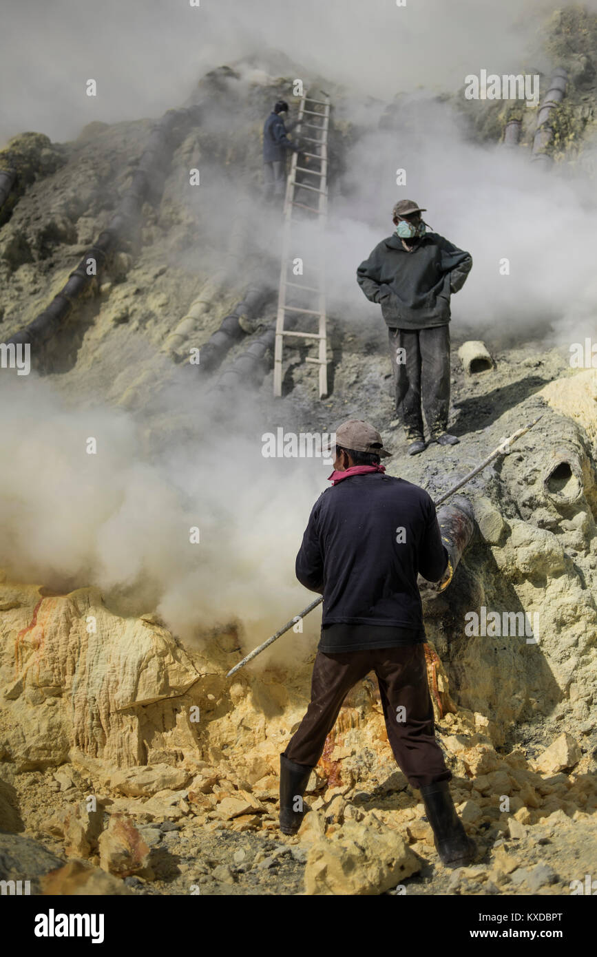 Miners extracting fresh sulfur rocks at crater of Kawah Ijen Volcano ...