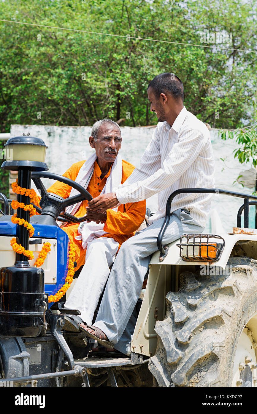 2 Indian Rural Farmer Father and son riding tractor Village Stock Photo ...
