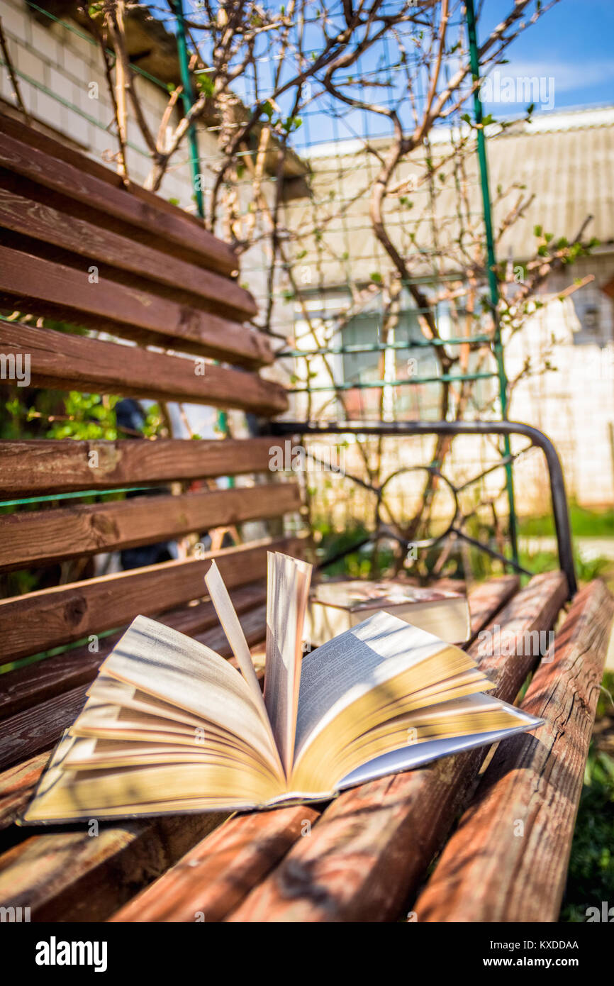 Open book on the wooden bench in the courtyard Stock Photo - Alamy