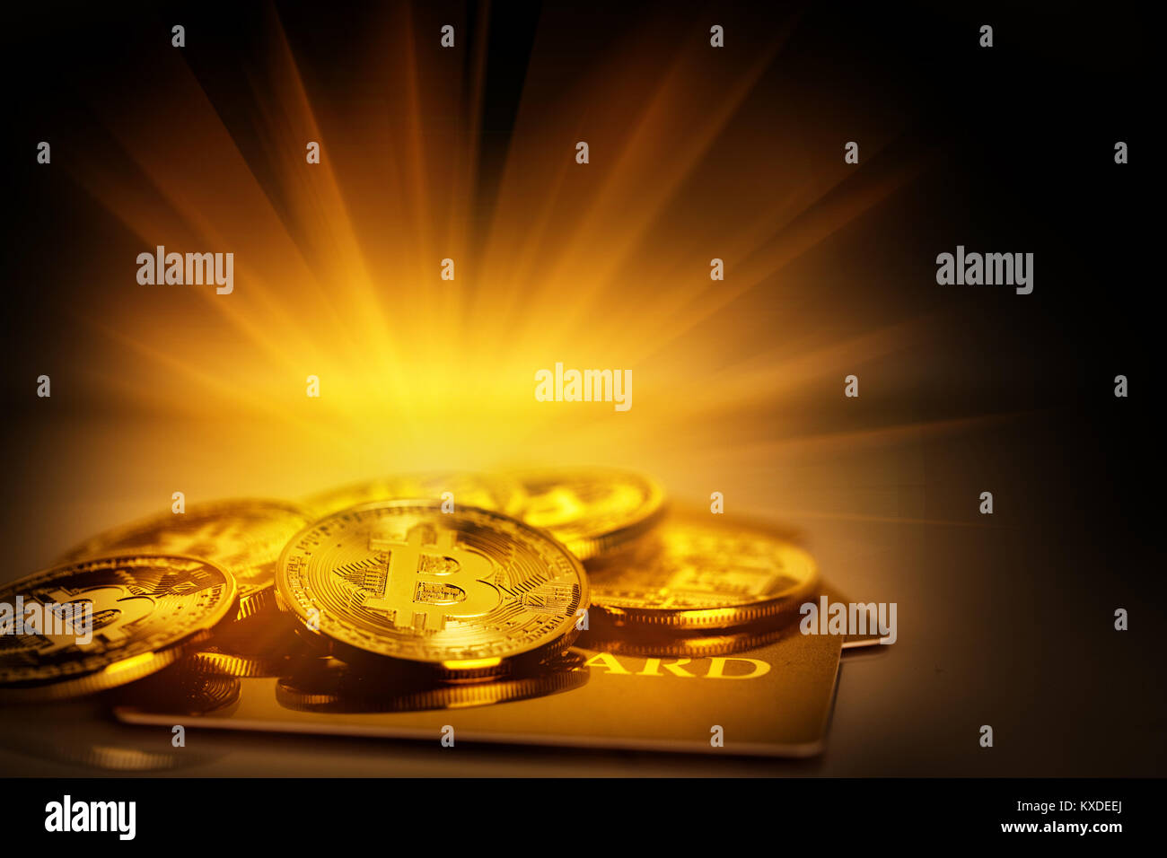 Shining pile of golden bitcoins and gold credit card in bright rays ...