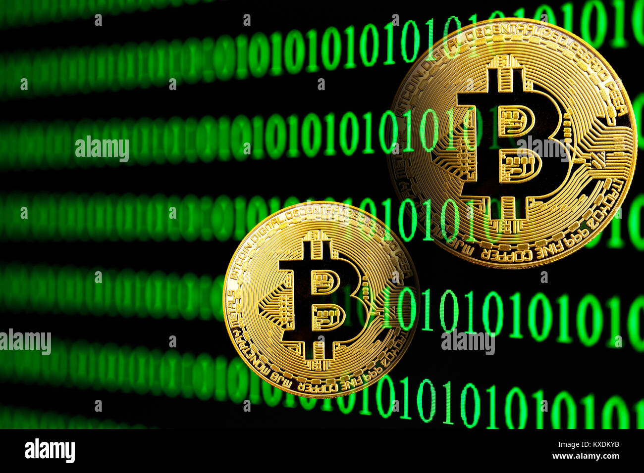 Symbol image digital currency, gold physical coins, bitcoins in front of binary code Stock Photo ...