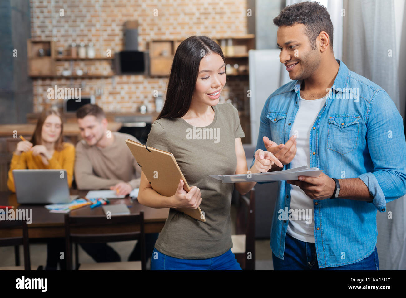Cheerful young woman pointing to the documents and smiling kindly Stock ...