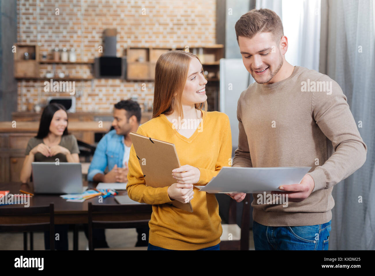 Young man showing the documents while his beautiful colleague looking ...