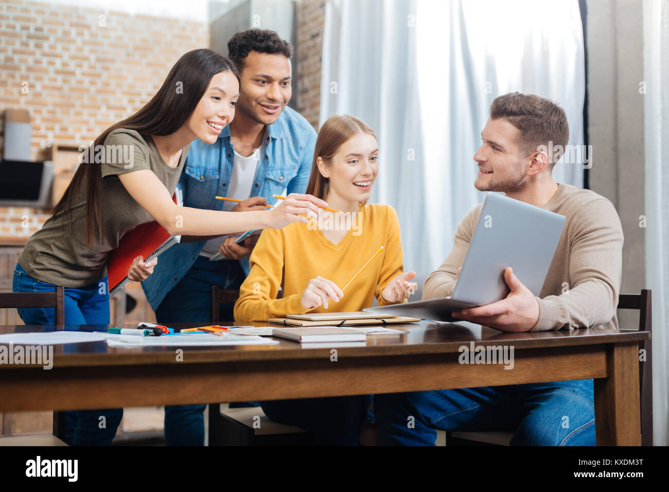 Excited students looking at the screen of a laptop and being surprised ...