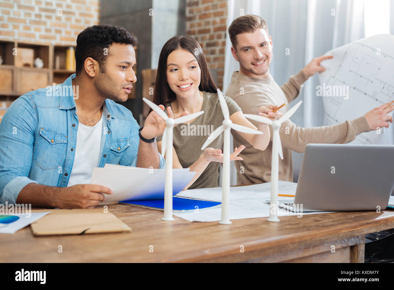 Excited engineers admiring the miniatures of windmill turbines and ...
