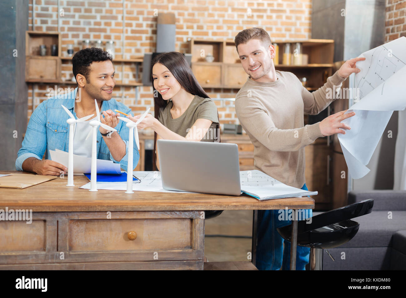 Enthusiastic professional engineers touching windmill turbines Stock ...