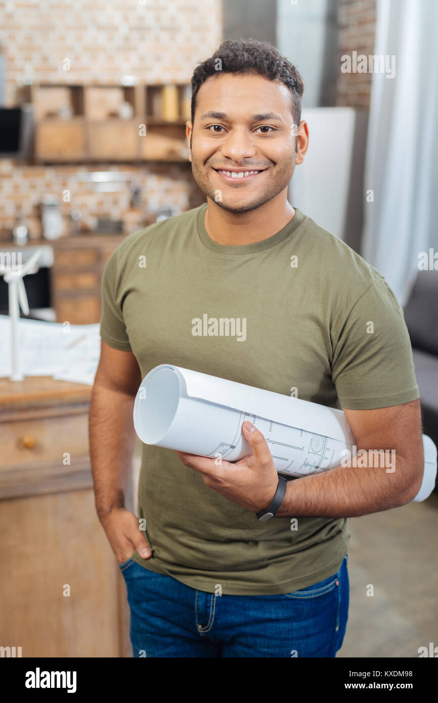 Clever emotional engineer feeling glad and smiling after finishing his ...