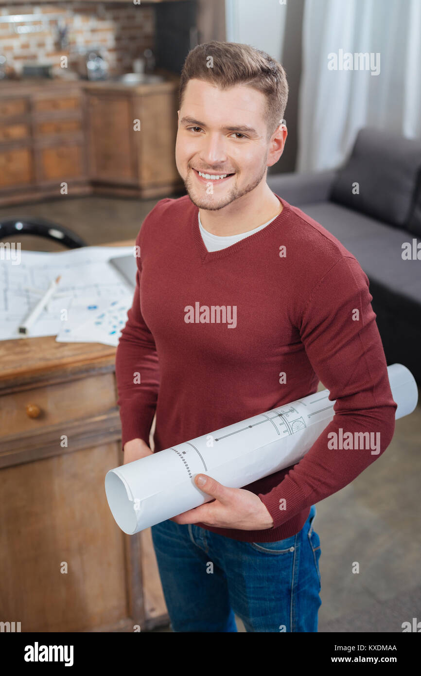 Positive young man smiling while standing with a ready drawing Stock ...