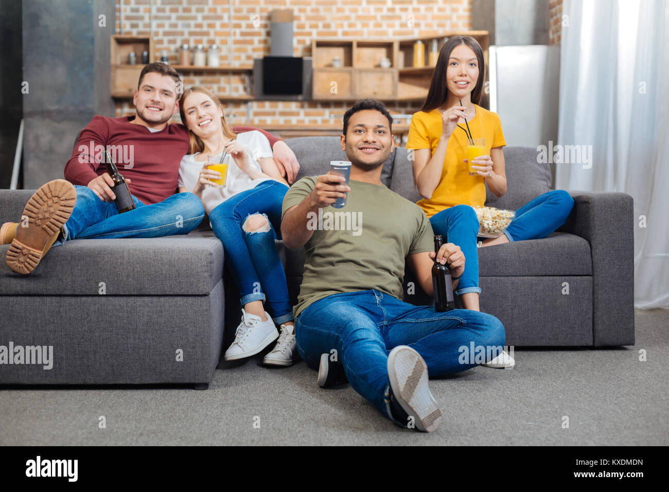 Young smiling people sitting together and watching TV Stock Photo - Alamy