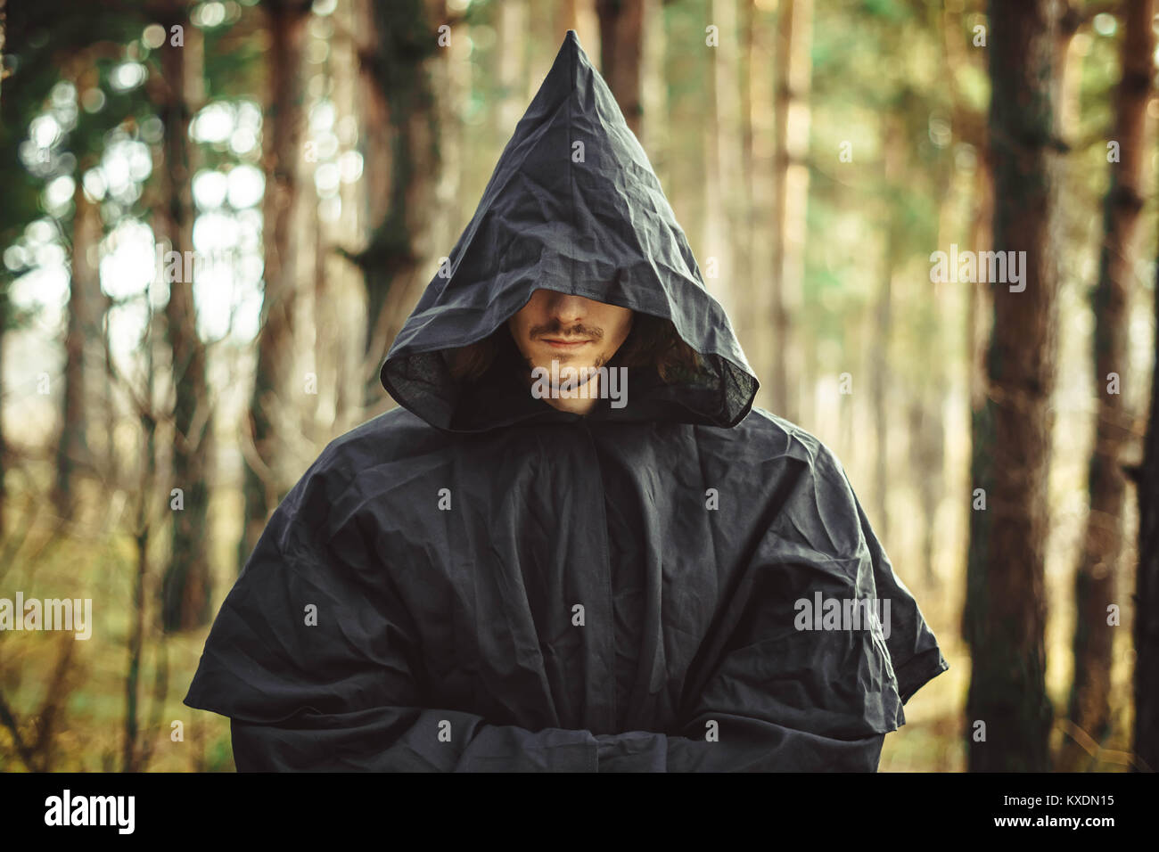 A creepy man in a black hood in the forest Stock Photo - Alamy