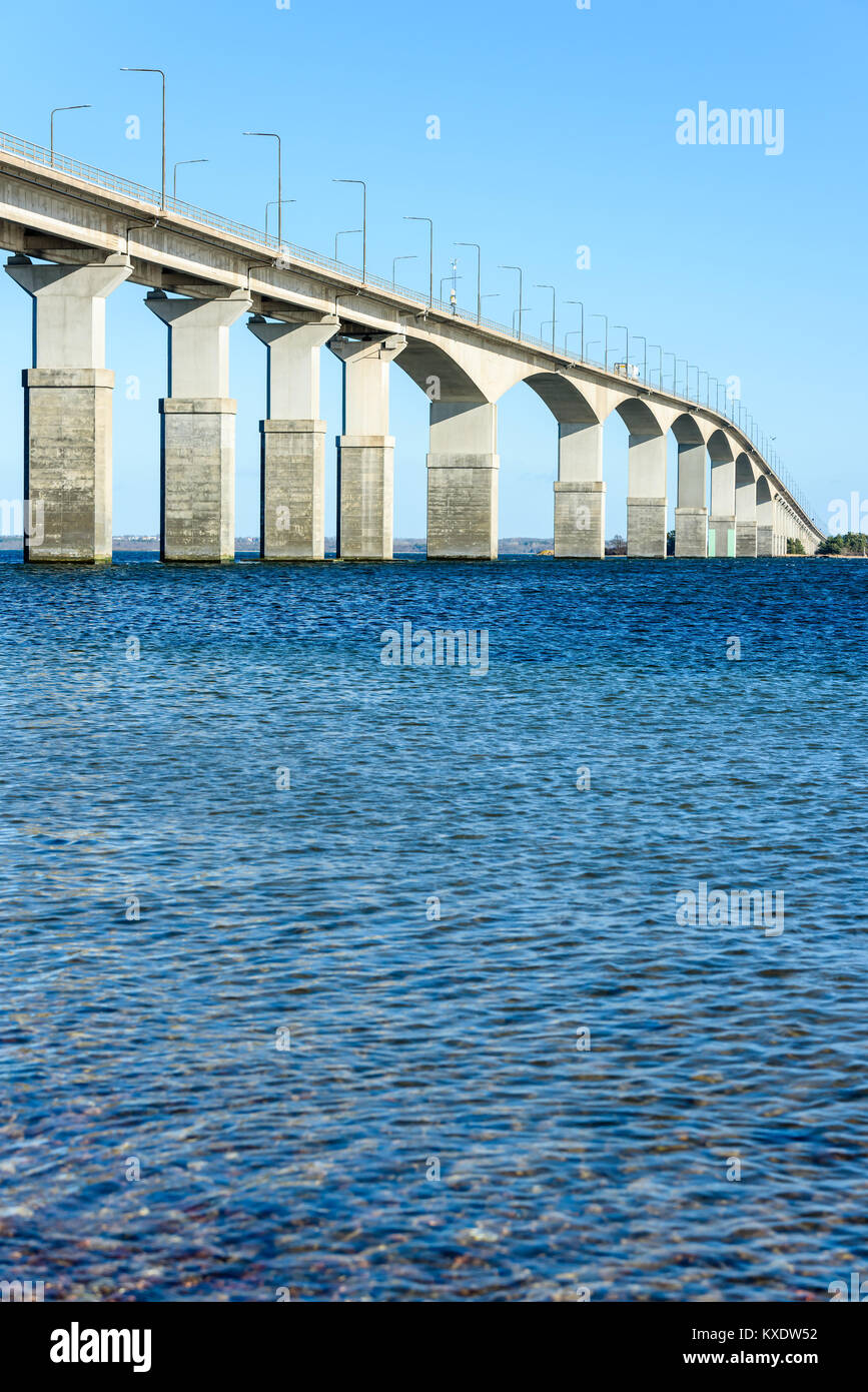Concrete bridge over water. Gray pillars support the weight of the ...