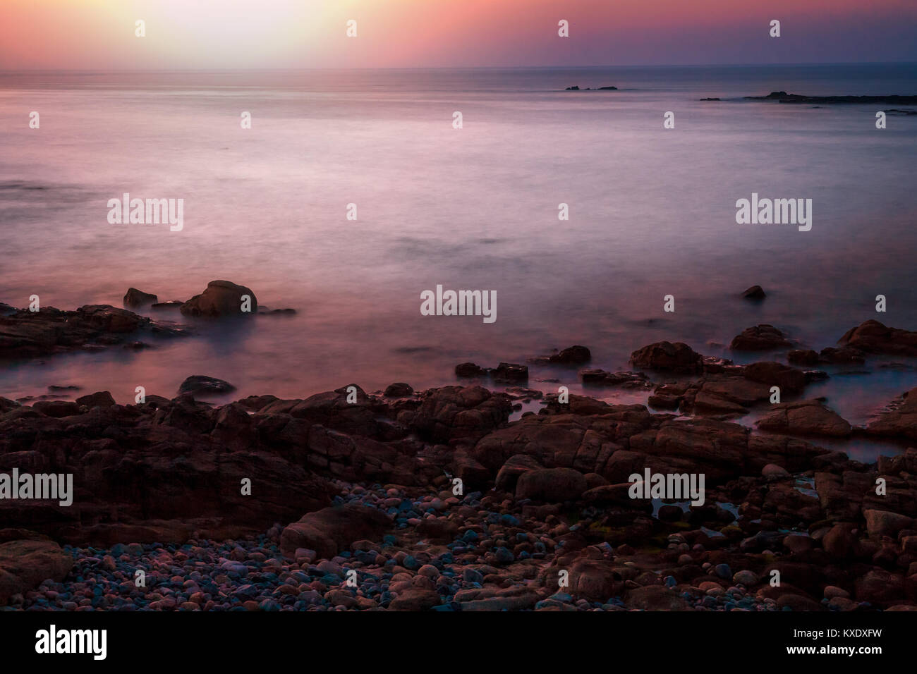 Sunset over the ocean on a rocky coastal outcrop. Taken at Sennen Cove ...