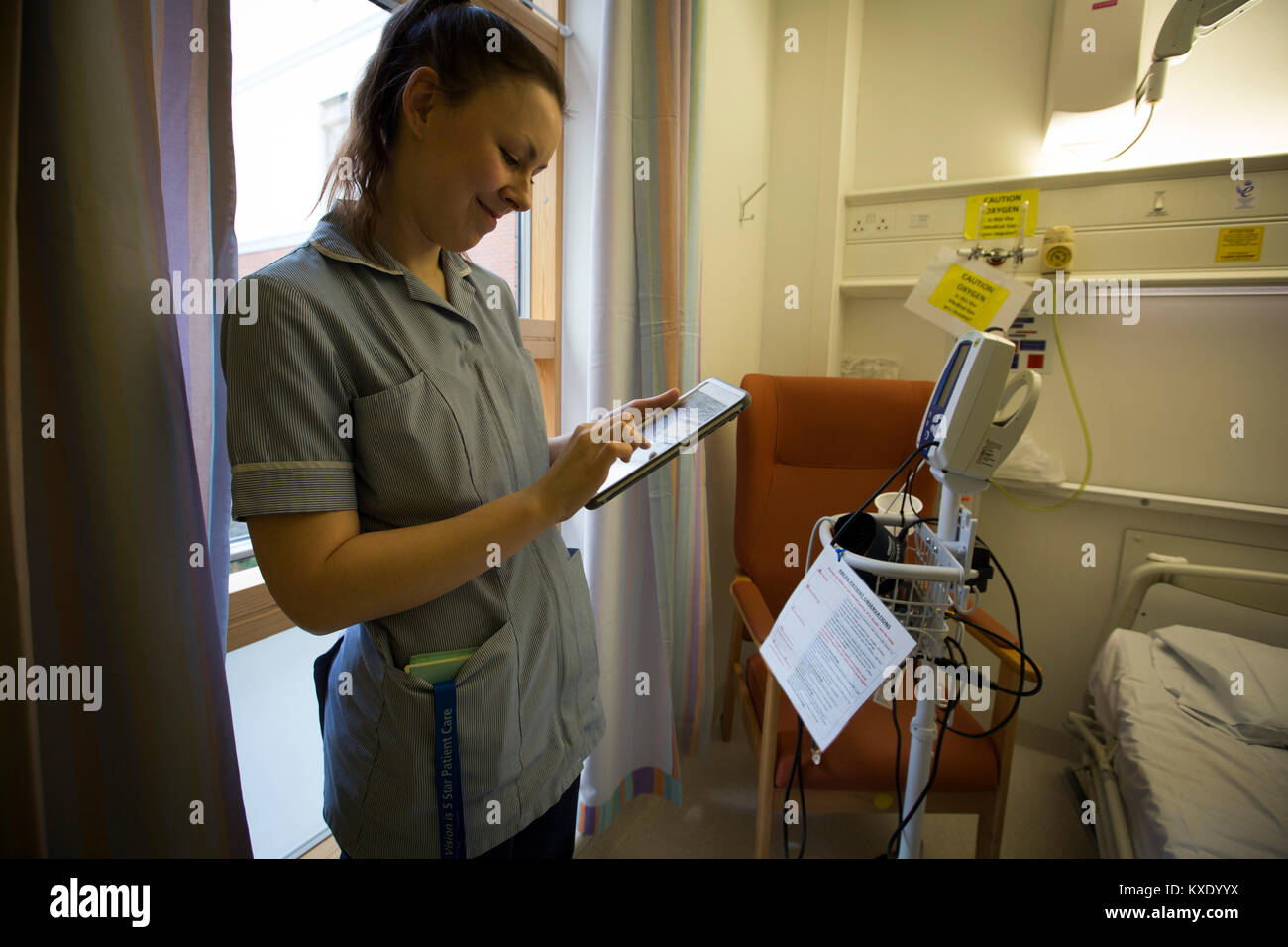 Staff nurse Charlotte Howden, inputting data into an iPad on a ward at ...