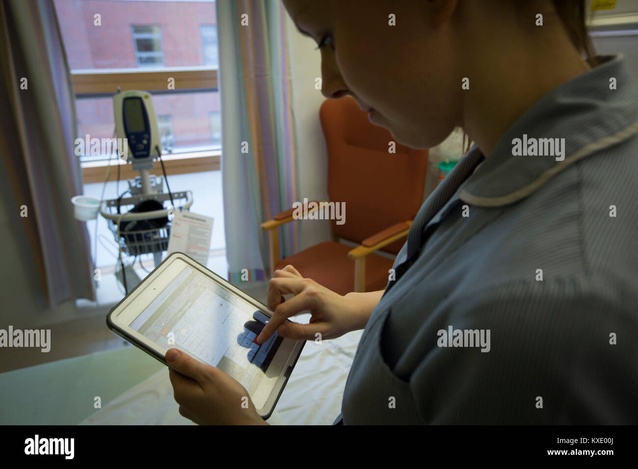 Staff nurse Charlotte Howden, inputting data into an iPad on a ward at ...