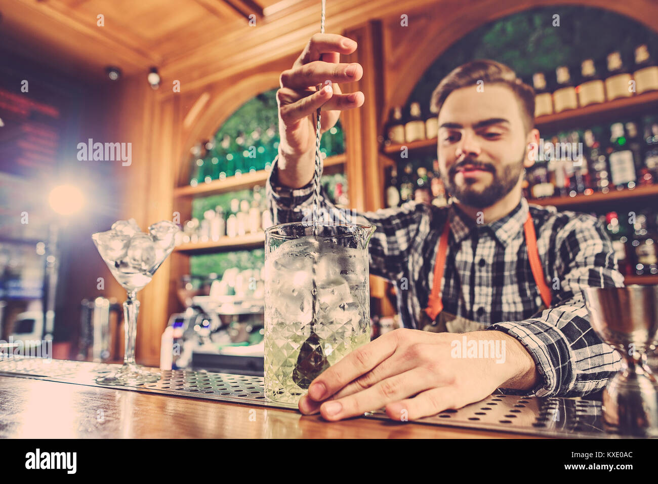 Barman making an alcoholic cocktail at the bar counter on the bar ...