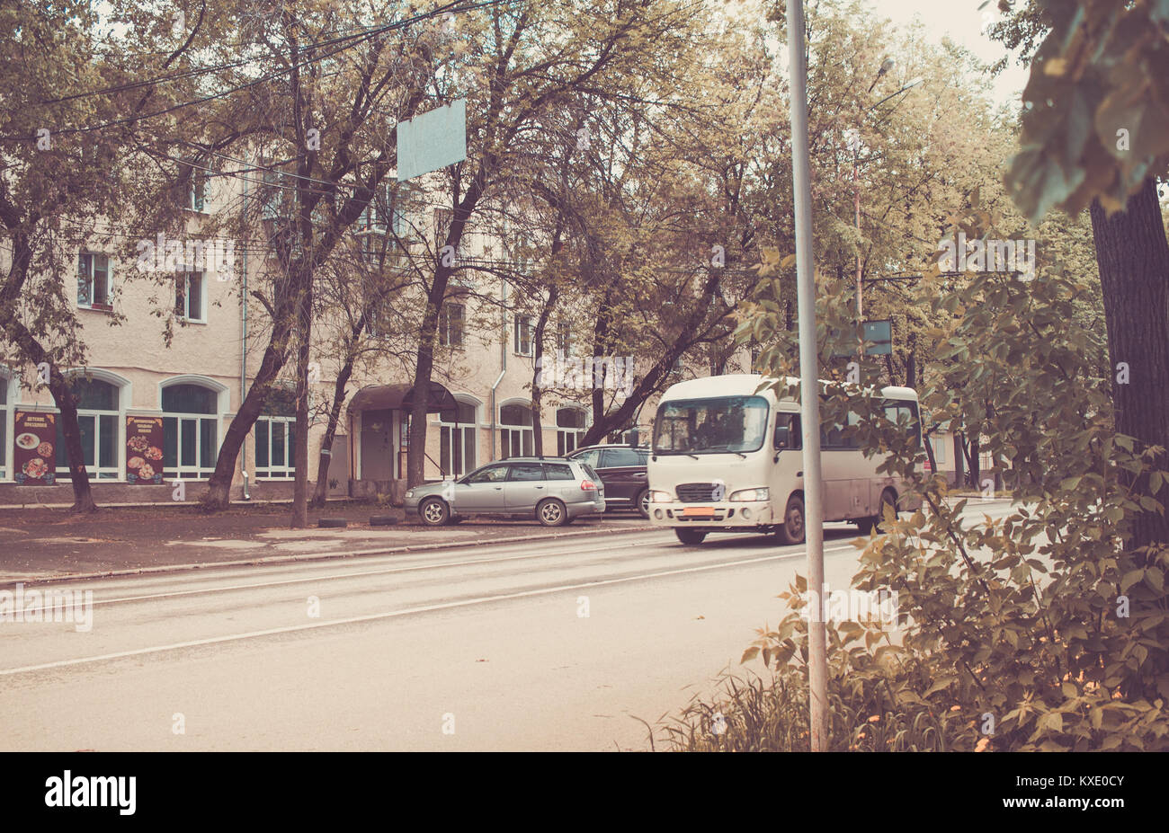 Urban landscape with old bus on road. Retro toned Stock Photo - Alamy