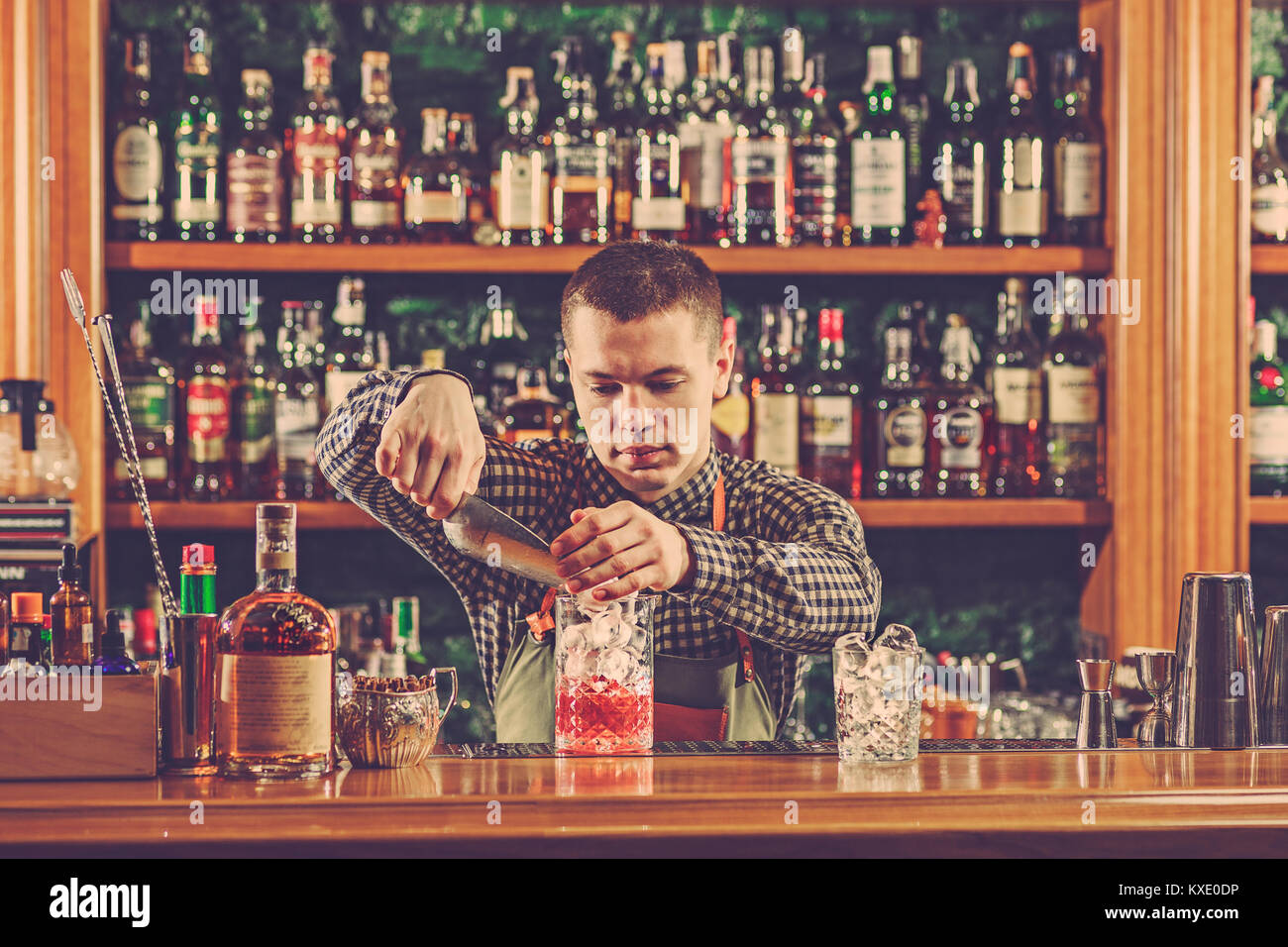 Barman making an alcoholic cocktail at the bar counter on the bar ...