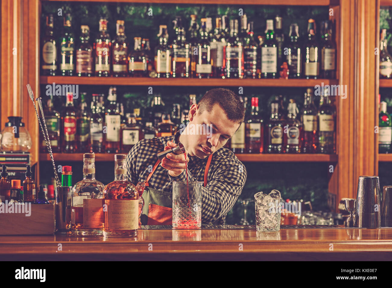 Barman making an alcoholic cocktail at the bar counter on the bar ...