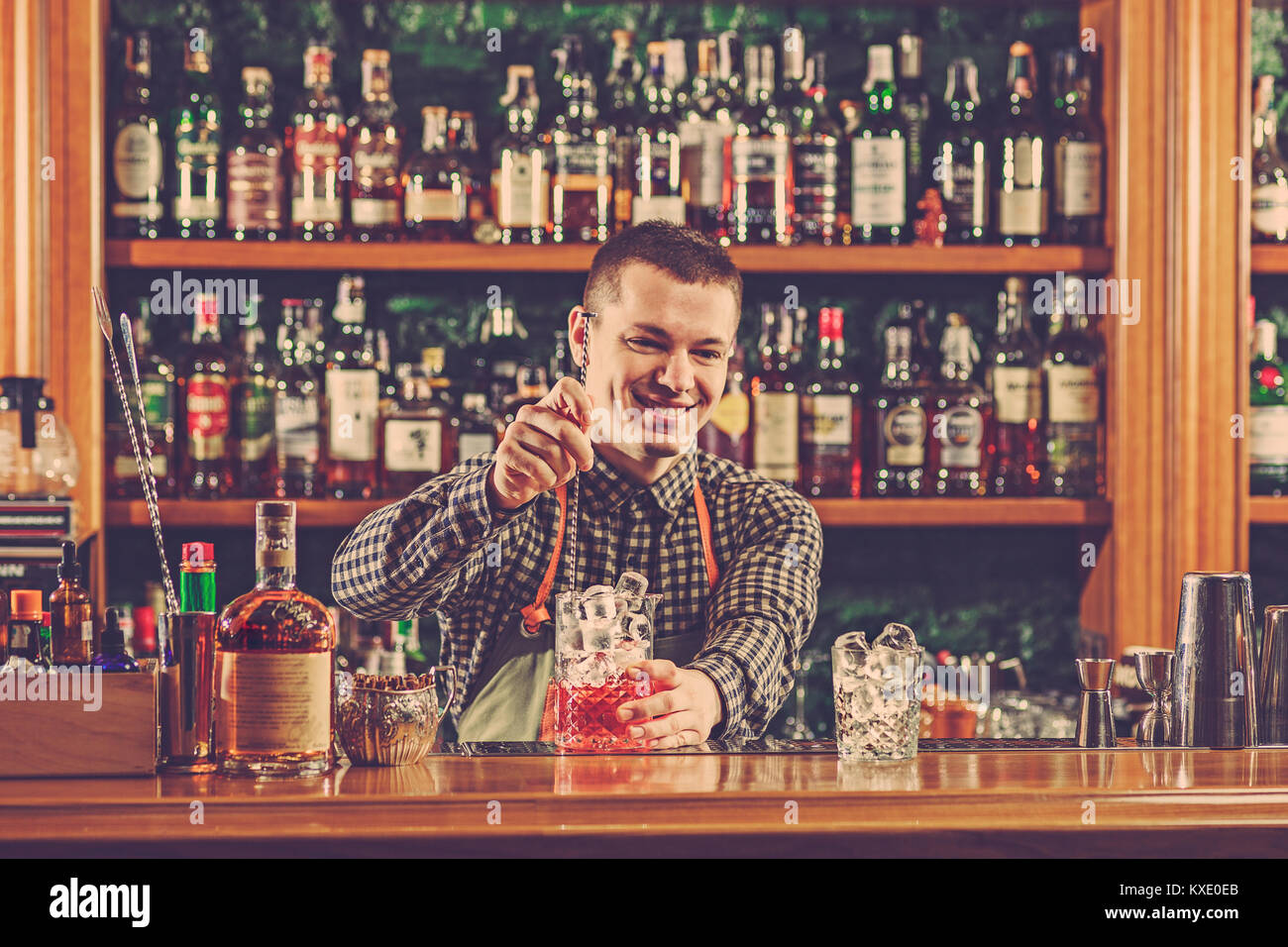 Barman making an alcoholic cocktail at the bar counter on the bar ...