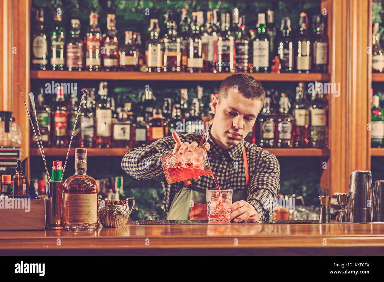 Barman making an alcoholic cocktail at the bar counter on the bar ...