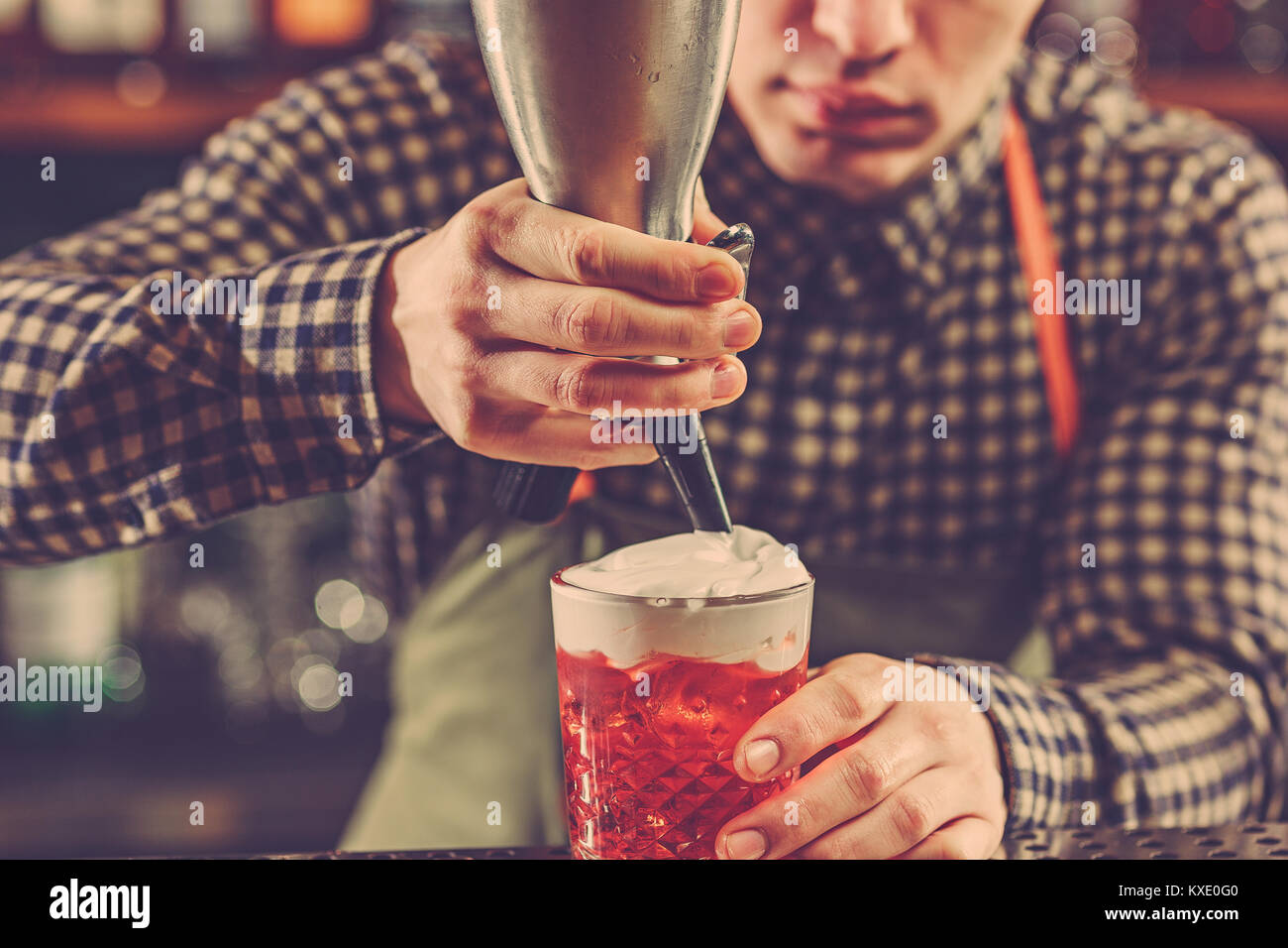 Barman making an alcoholic cocktail at the bar counter on the bar ...