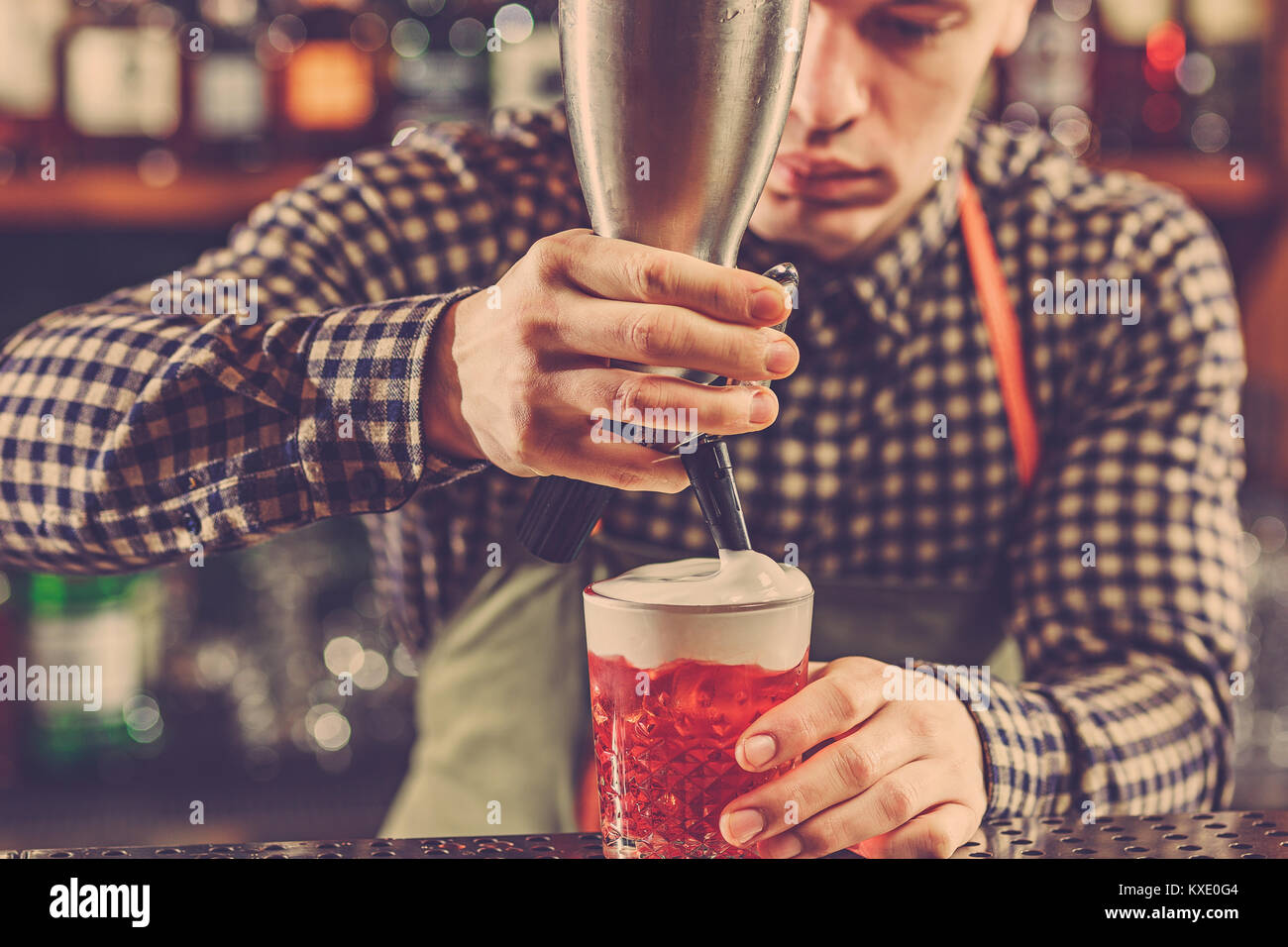 Barman making an alcoholic cocktail at the bar counter on the bar ...