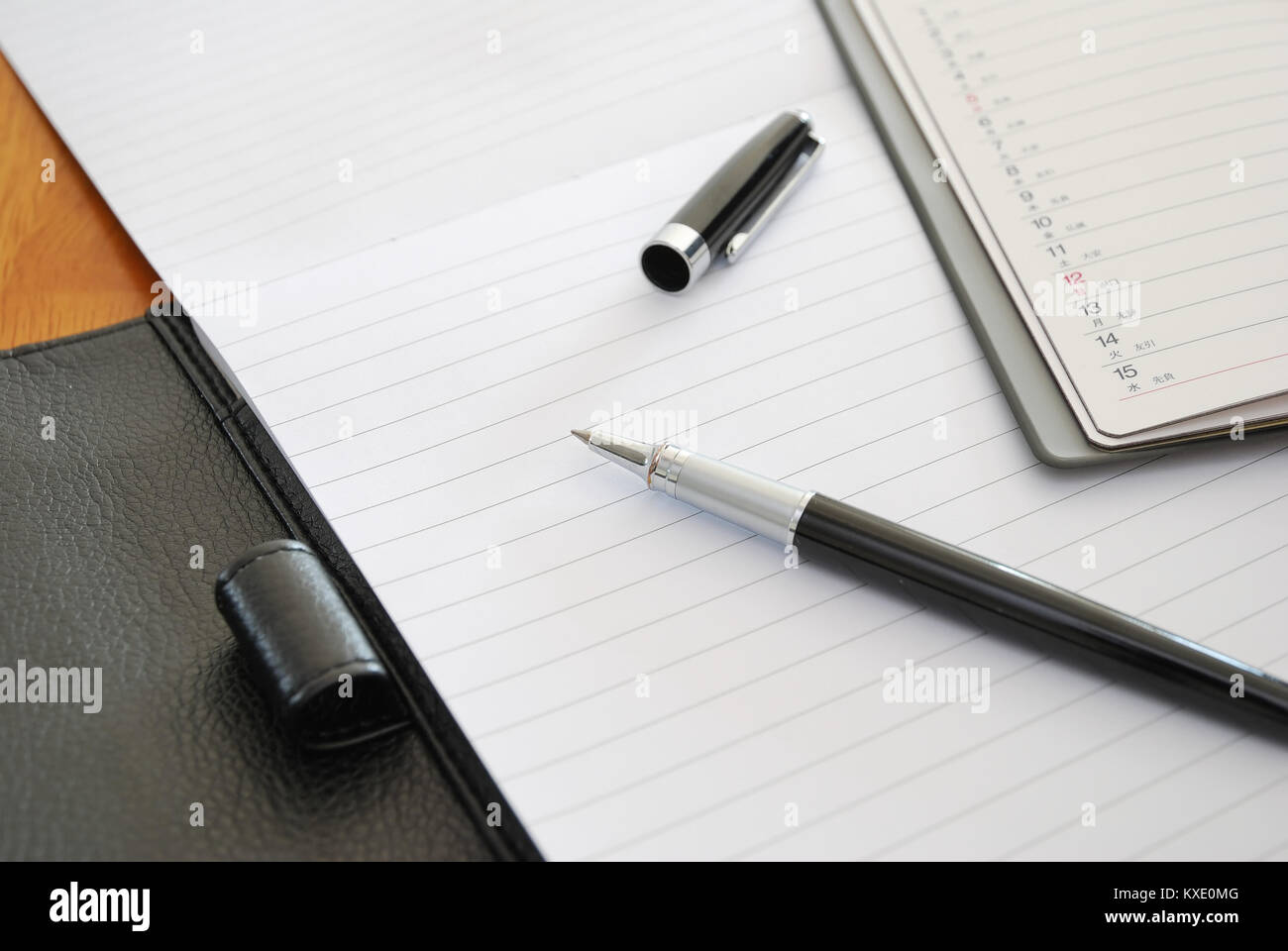 Black pen on blank writing pad or planner signifying concepts such as ...