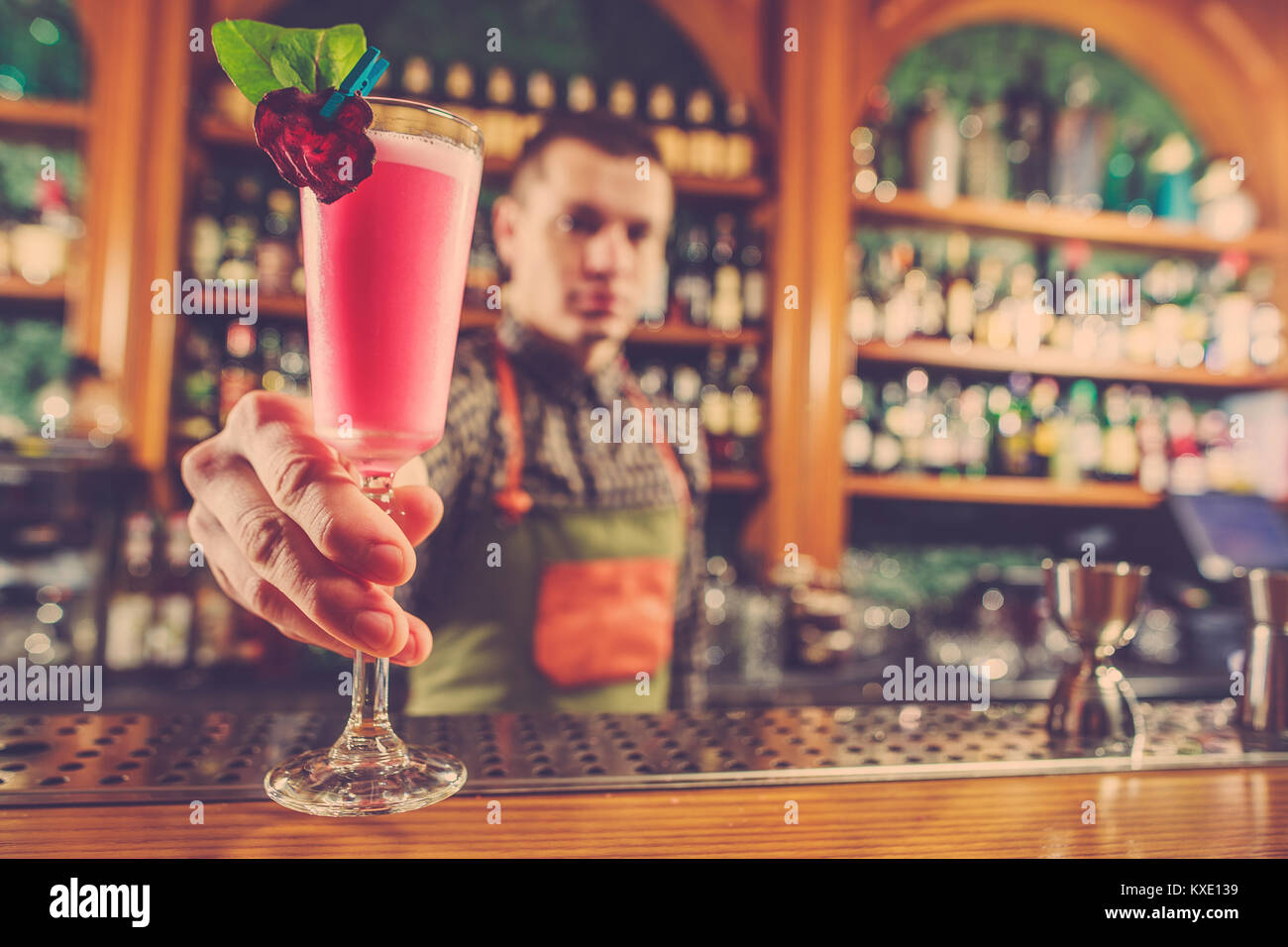 Barman offering an alcoholic cocktail at the bar counter on the bar ...