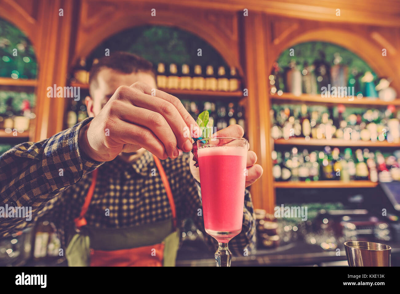 Barman making an alcoholic cocktail at the bar counter on the bar ...