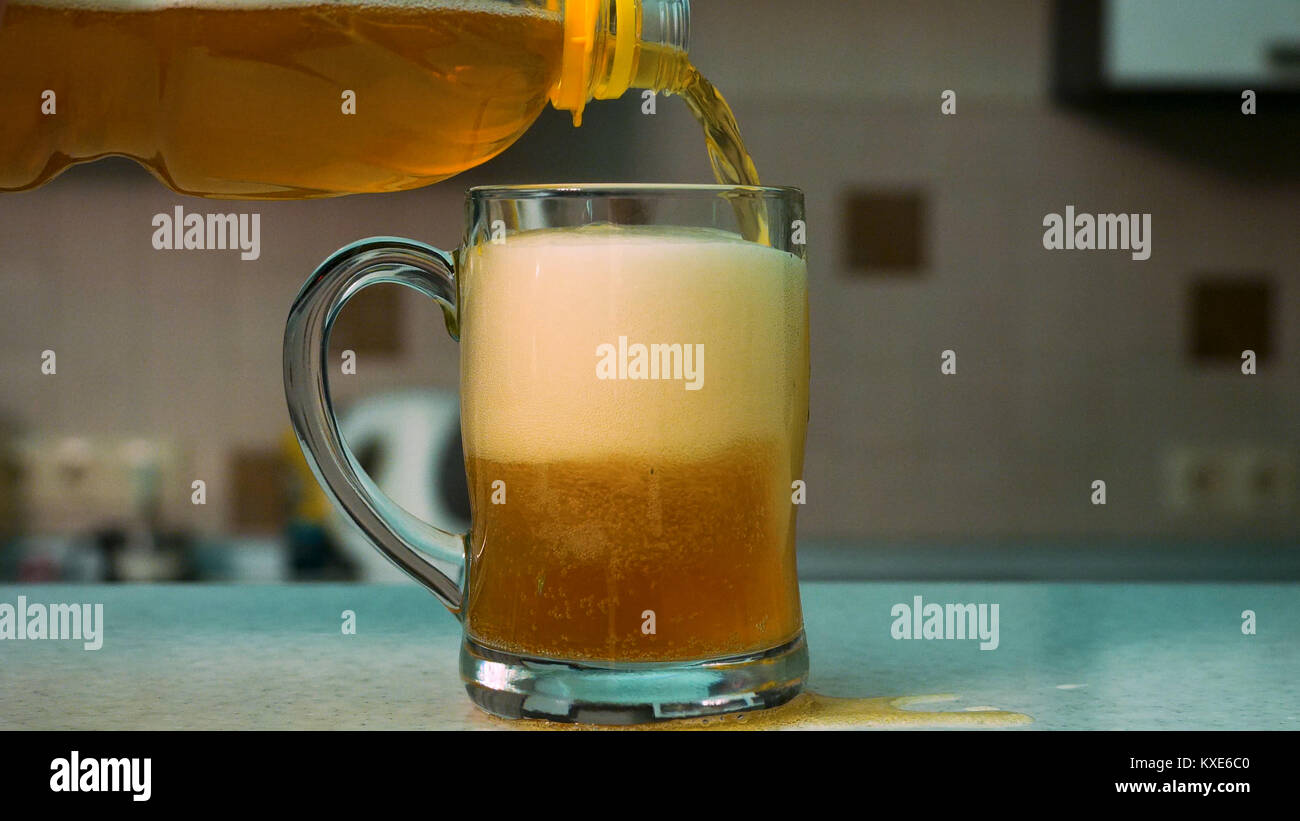 Beer pouring from bottle into glass. Close up of bottle of beer pouring into a glass. Cold ...