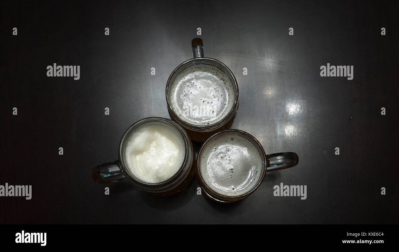 Cheers. Top view of people holding mugs with beer. Top down shot of ...
