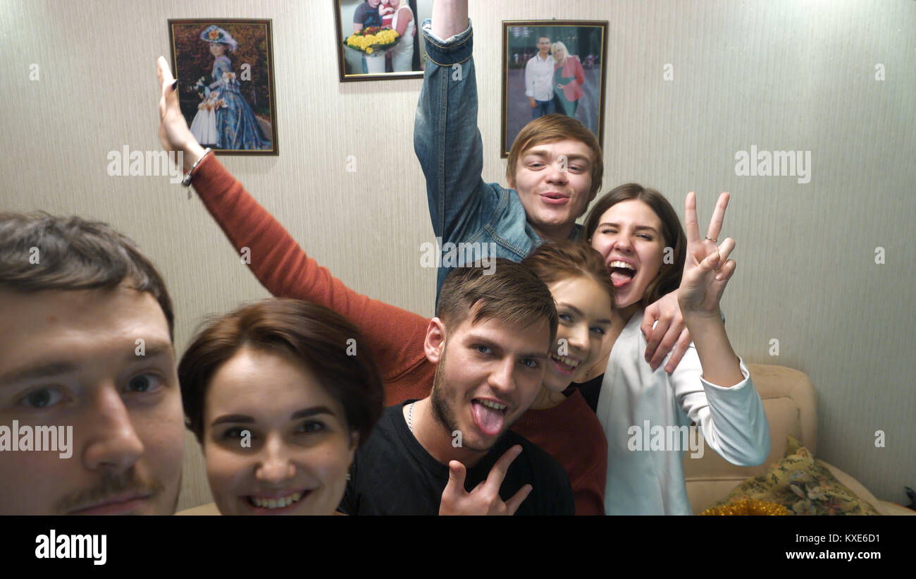 Six young carefree attractive happy friends gesturing v-sign while ...