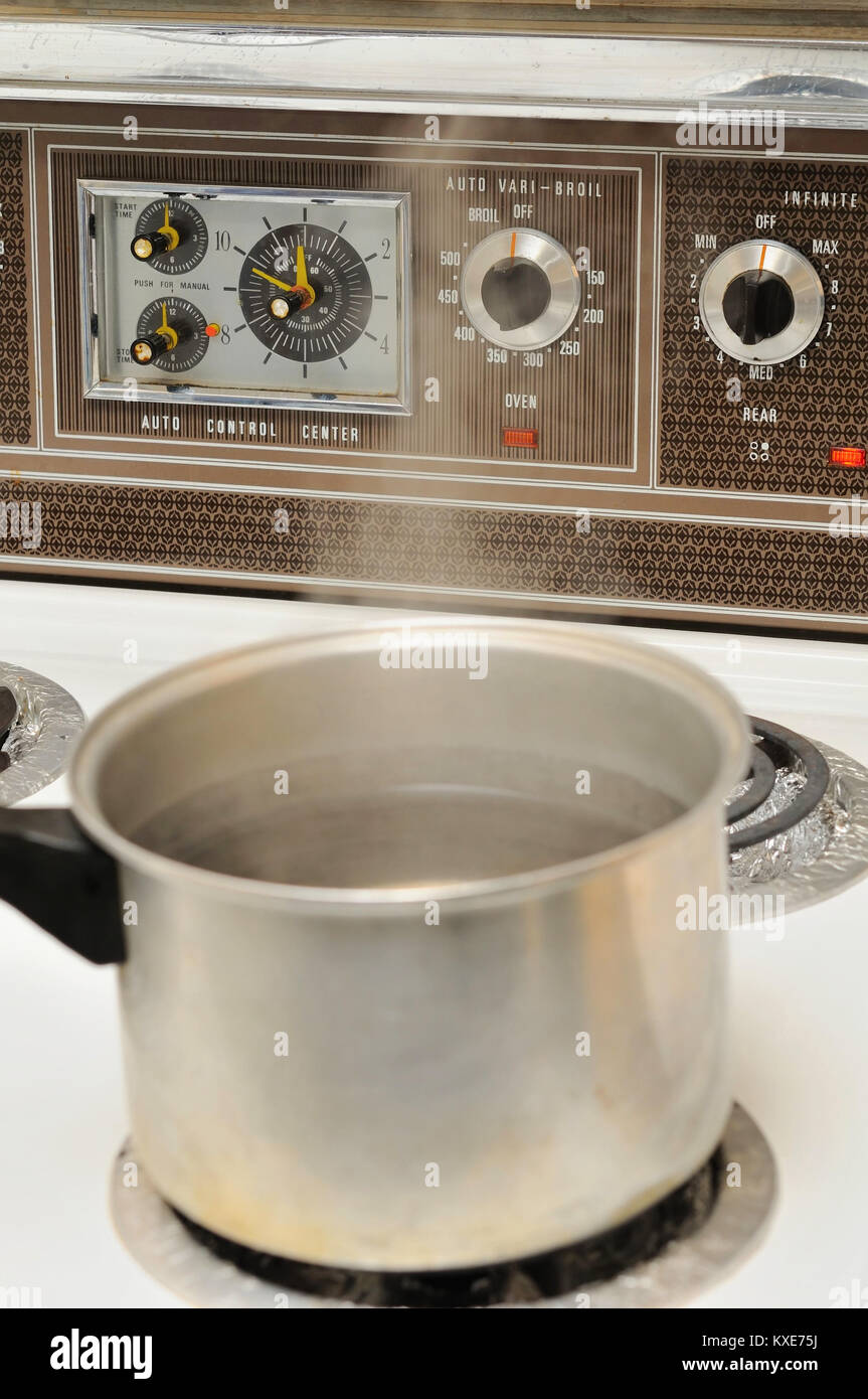Cooking pot on generic stove with boiling water Stock Photo - Alamy