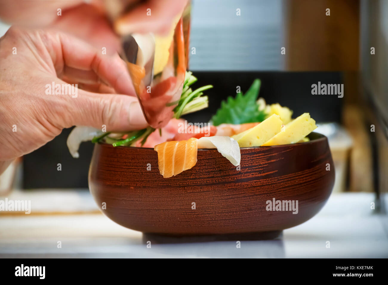 Closeup of a bowl of Sashimi with hands of Japanese chef TOKYO, JAPAN ...