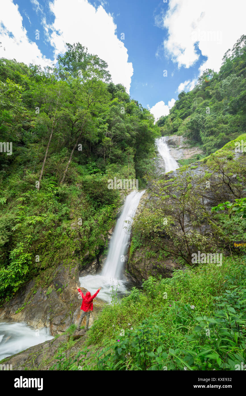 Tourist looking at the waterfall. Freedom, happiness, hiking concept ...