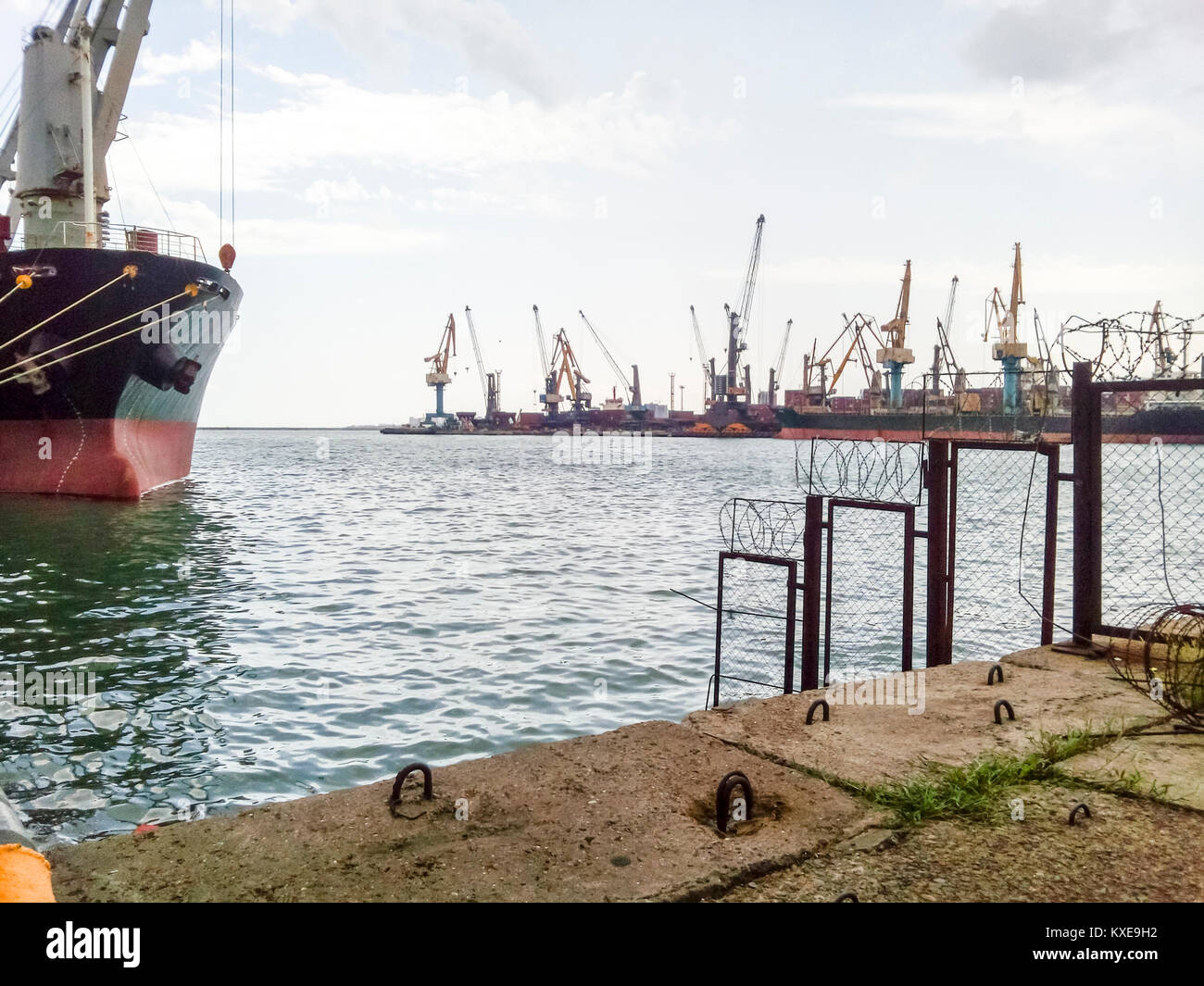 View of the sea and city beach from the port quay. Industrial port with ...