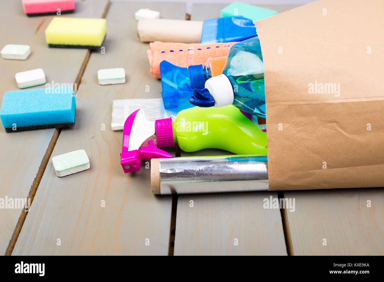 Full paper bag of different house cleaning product on wooden table ...