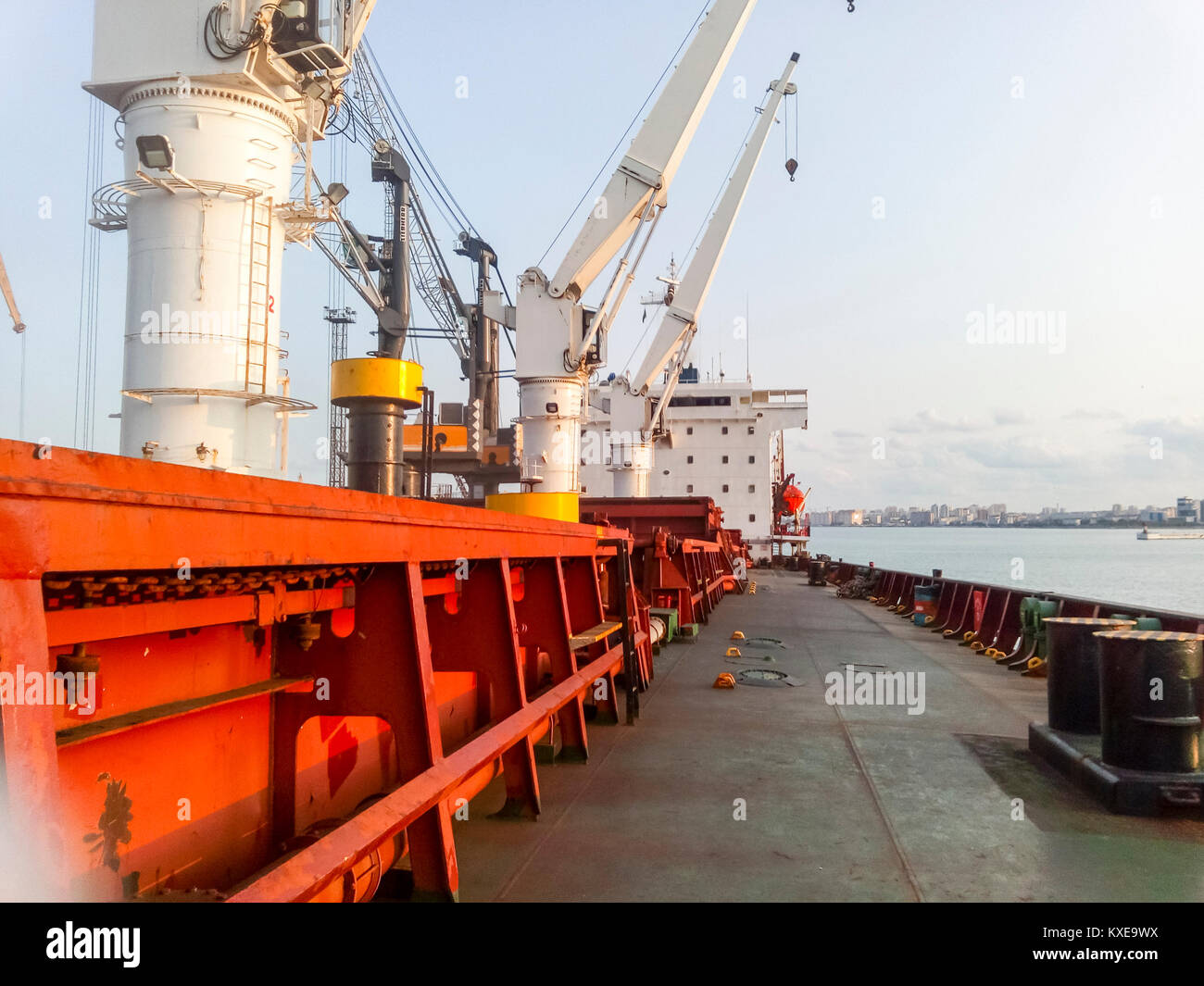 View of the sea and city beach from the port quay. Industrial port with ...