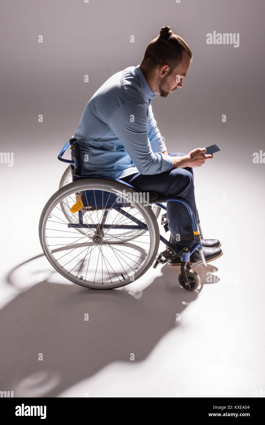 man in wheelchair using smartphone Stock Photo - Alamy