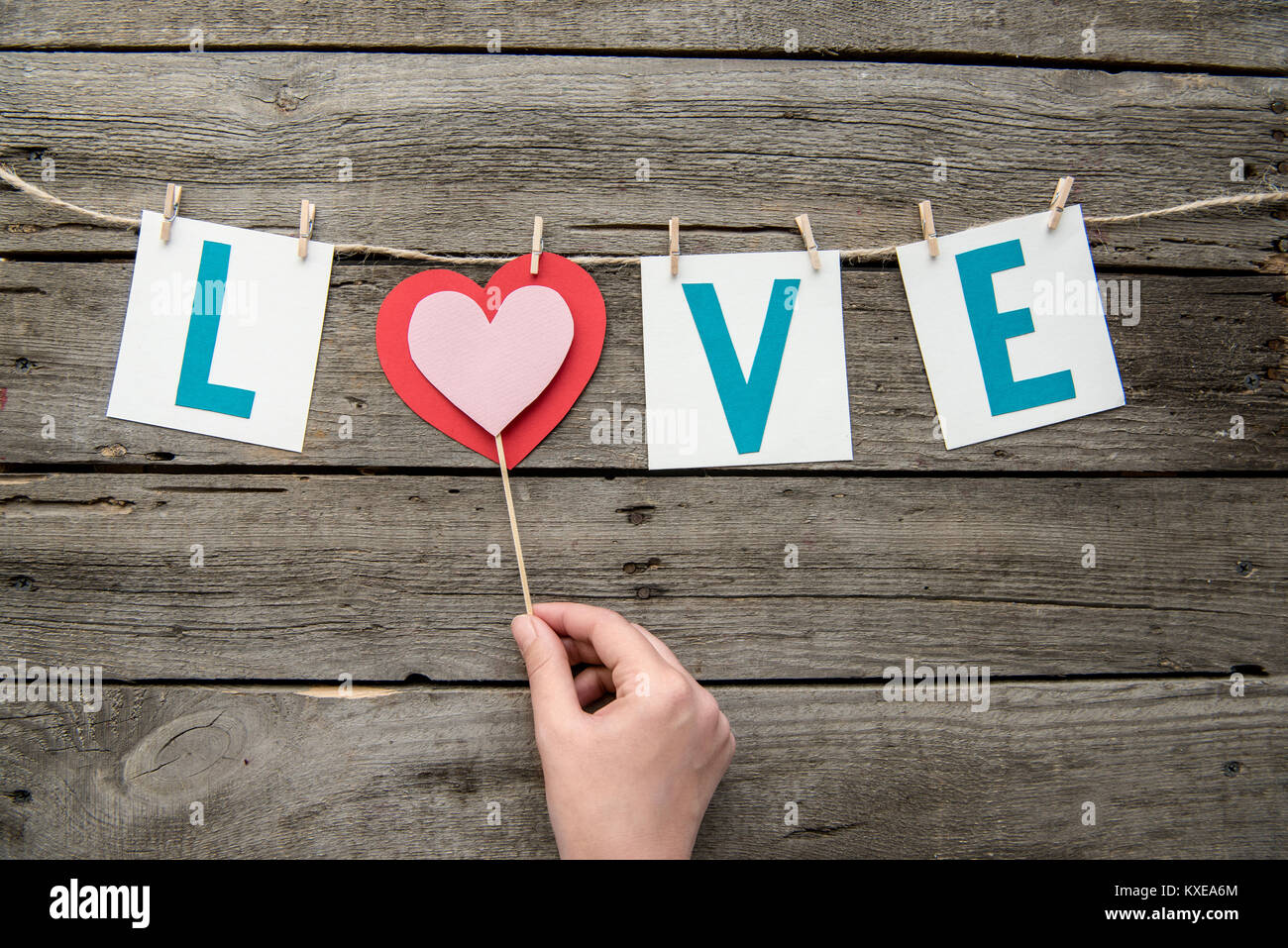 Handmade party decoration with love sign and human hand holding heart ...
