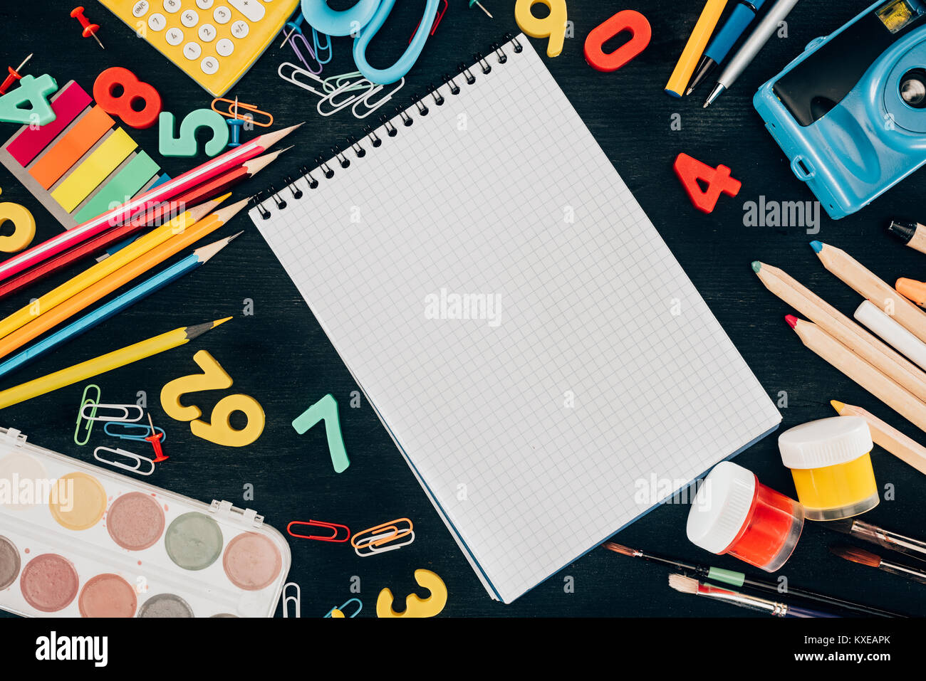 Top view of composition of colorful school supplies with blank notebook ...