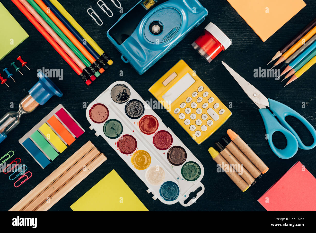 Flat lay composition of colorful school supplies isolated on dark board ...