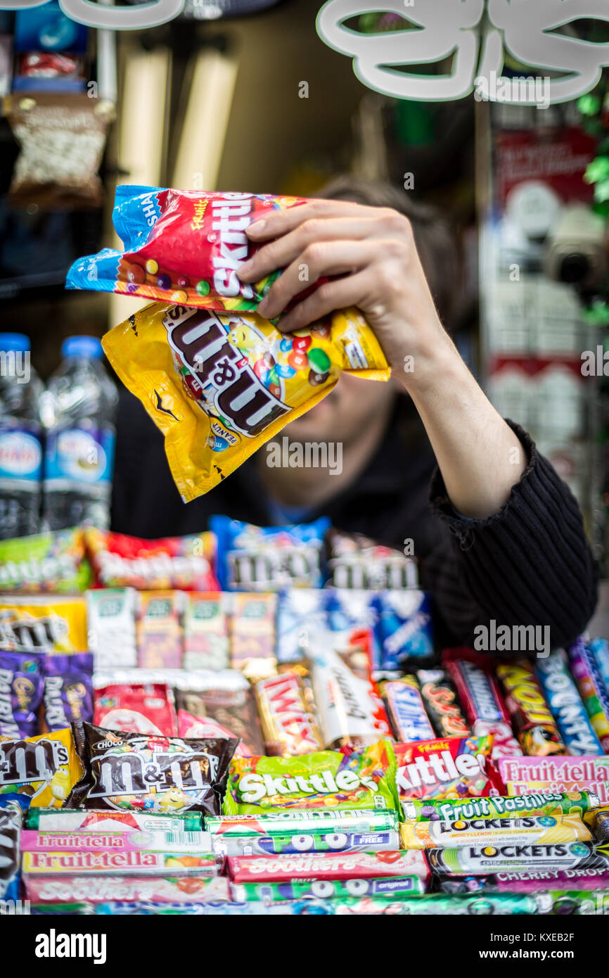 A sweet seller offers bags of chocolate candy Stock Photo - Alamy