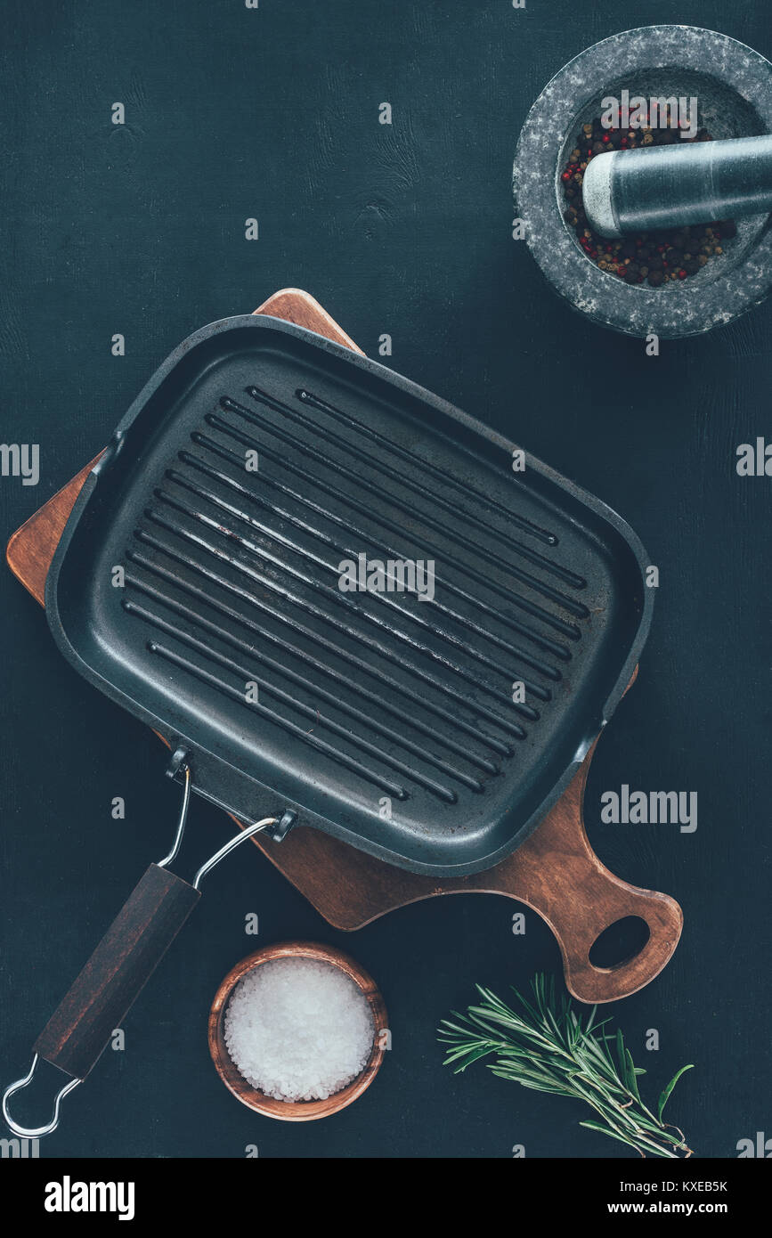 top view of empty grill pan with spices on black tabletop Stock Photo ...